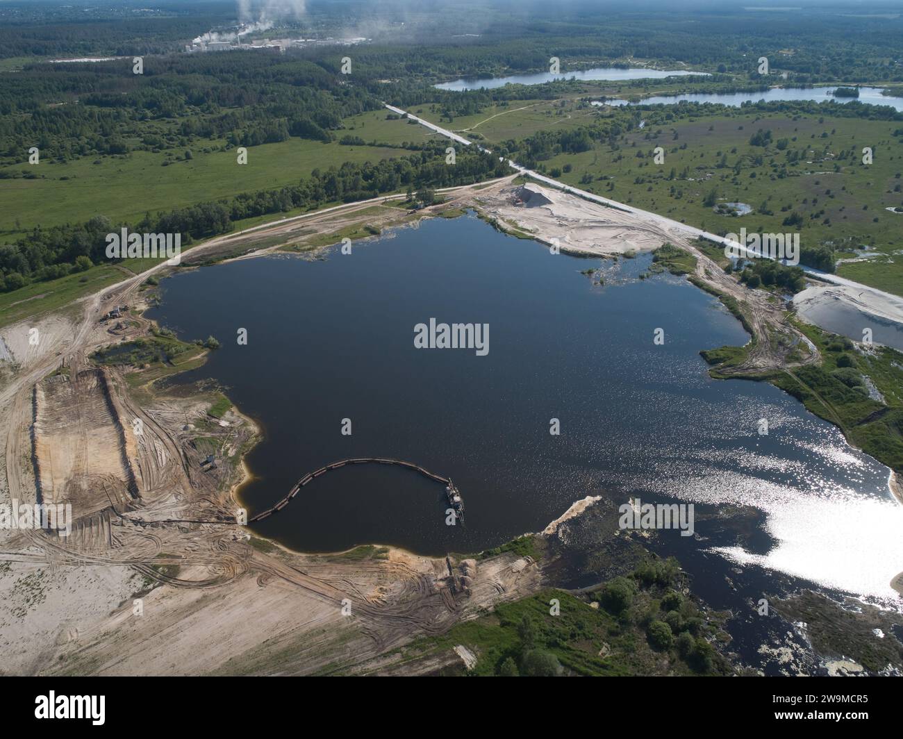 Suction tube dredger in sand mining quarry on sunny day Stock Photo - Alamy
