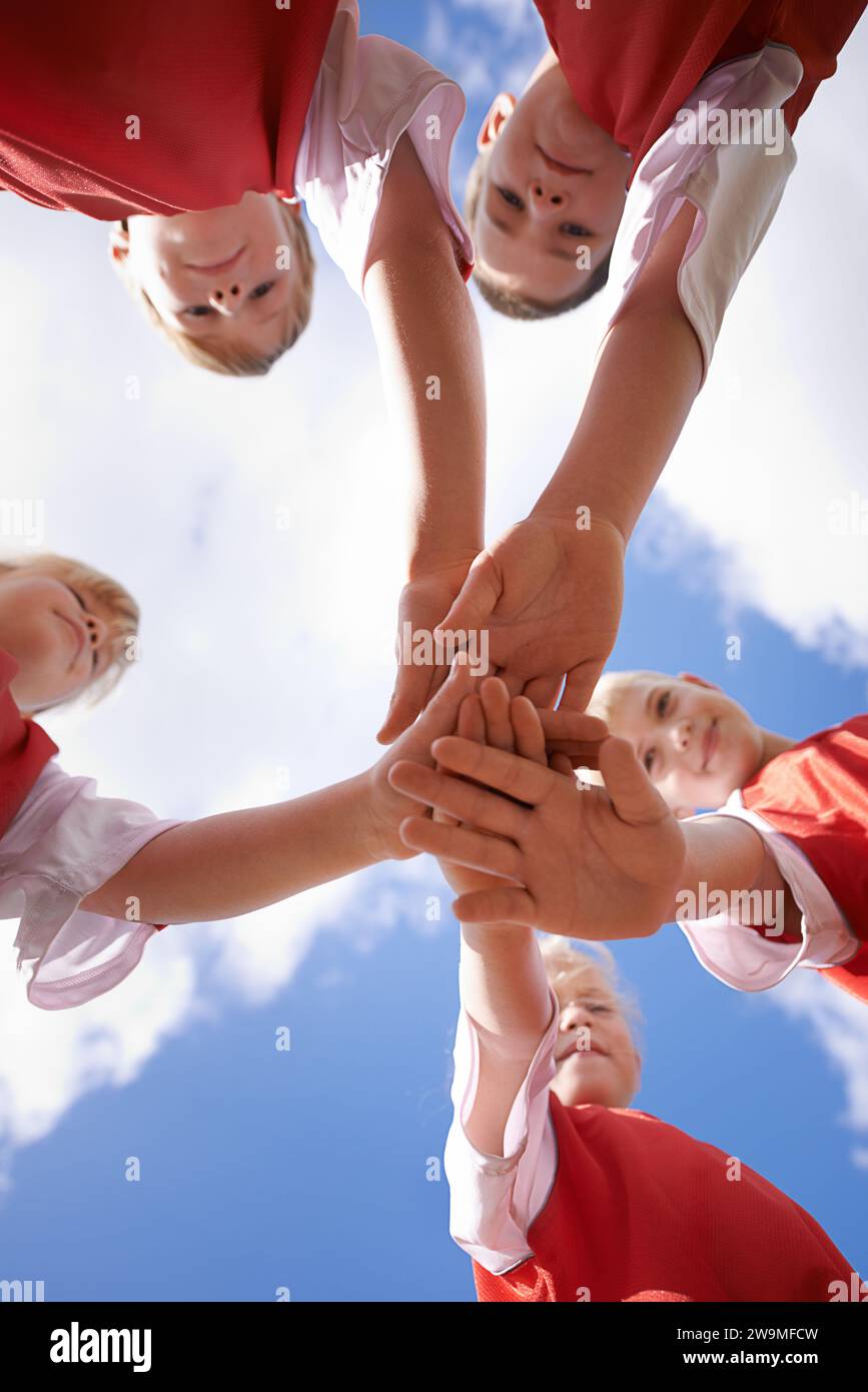 Hands, support and group of children on soccer team, team building and ...