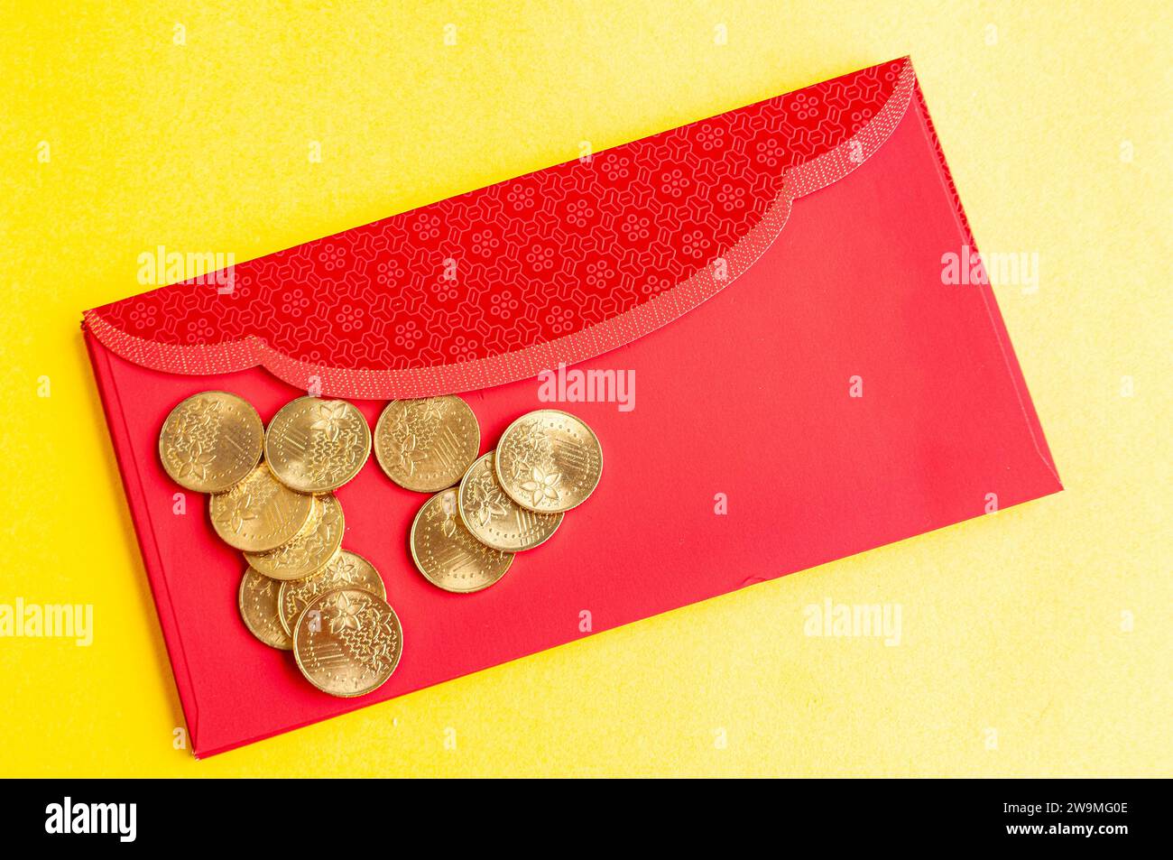 Top view of red envelopes with golden coins on yellow cover with ...