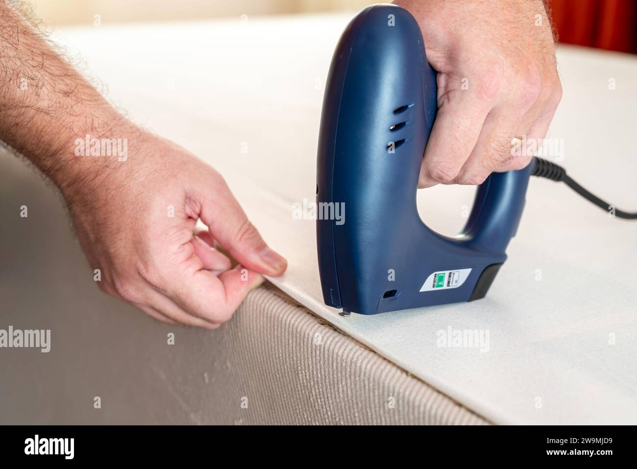 Worker stapling sofa lining with electric staple gun Stock Photo - Alamy