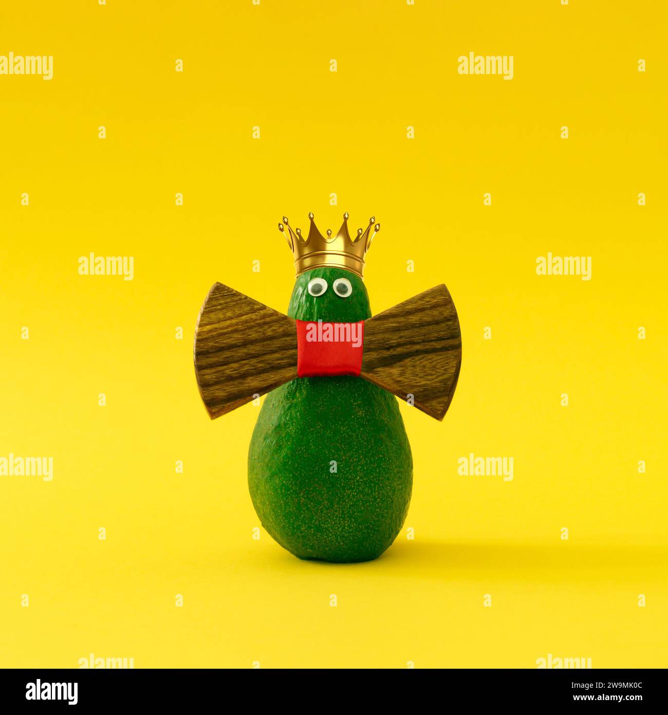 King avocado. Creative layout made of fresh avocado with crown and bow ...
