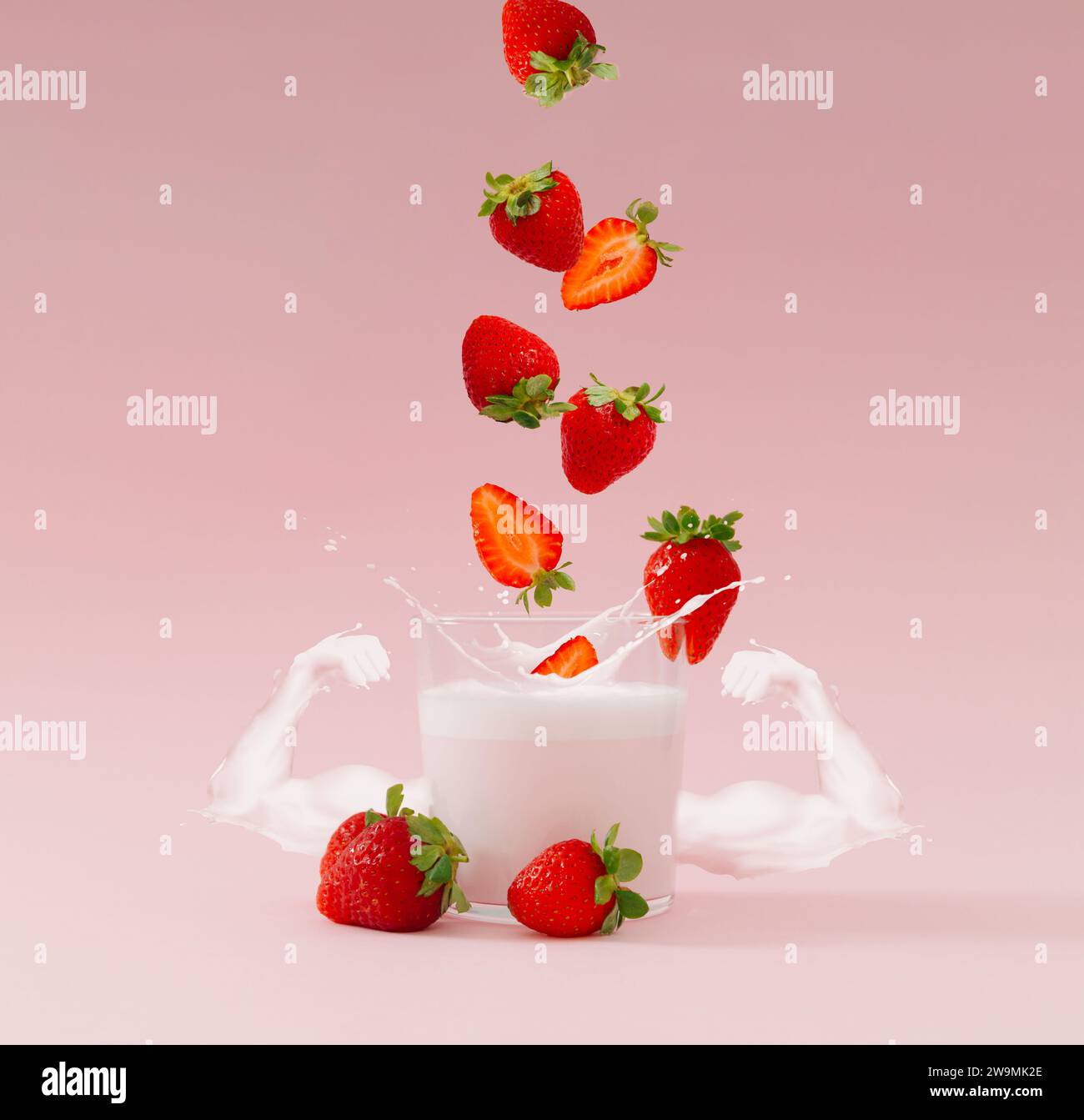 Creative layout made of strawberries falling into glass cup of milk drink with strawberry taste ...