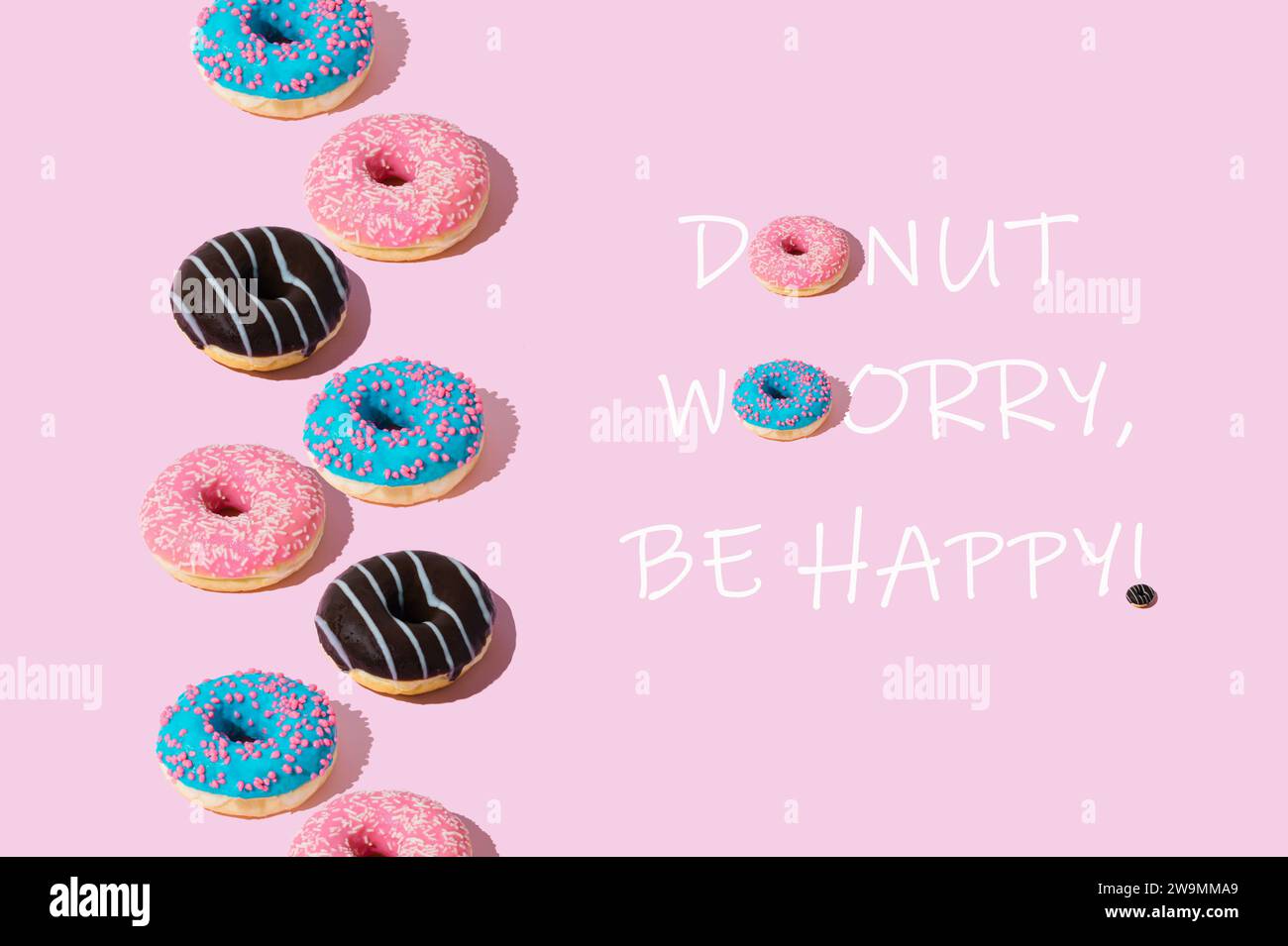 Creative arrangement of colorful donuts on pastel pink background with ...