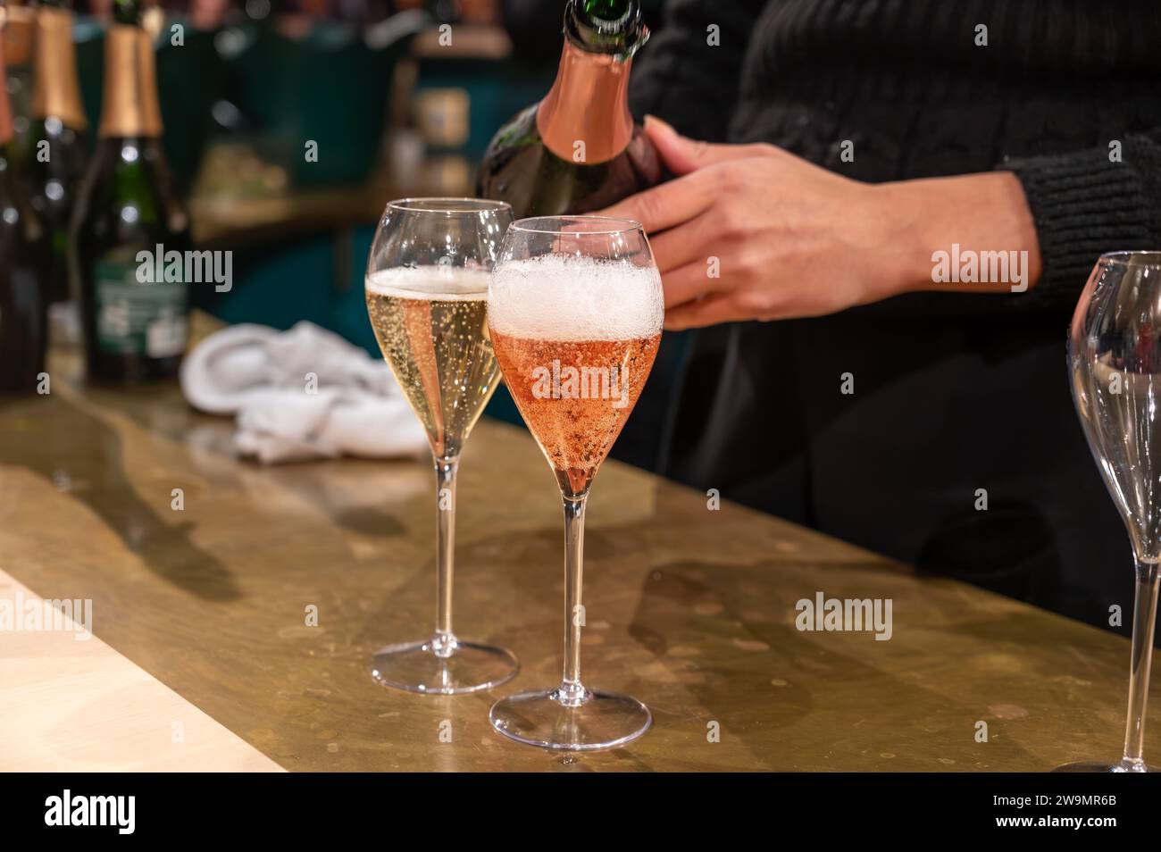 Pouring and tasting of dry sparkling wine champagne on winter weekend ...