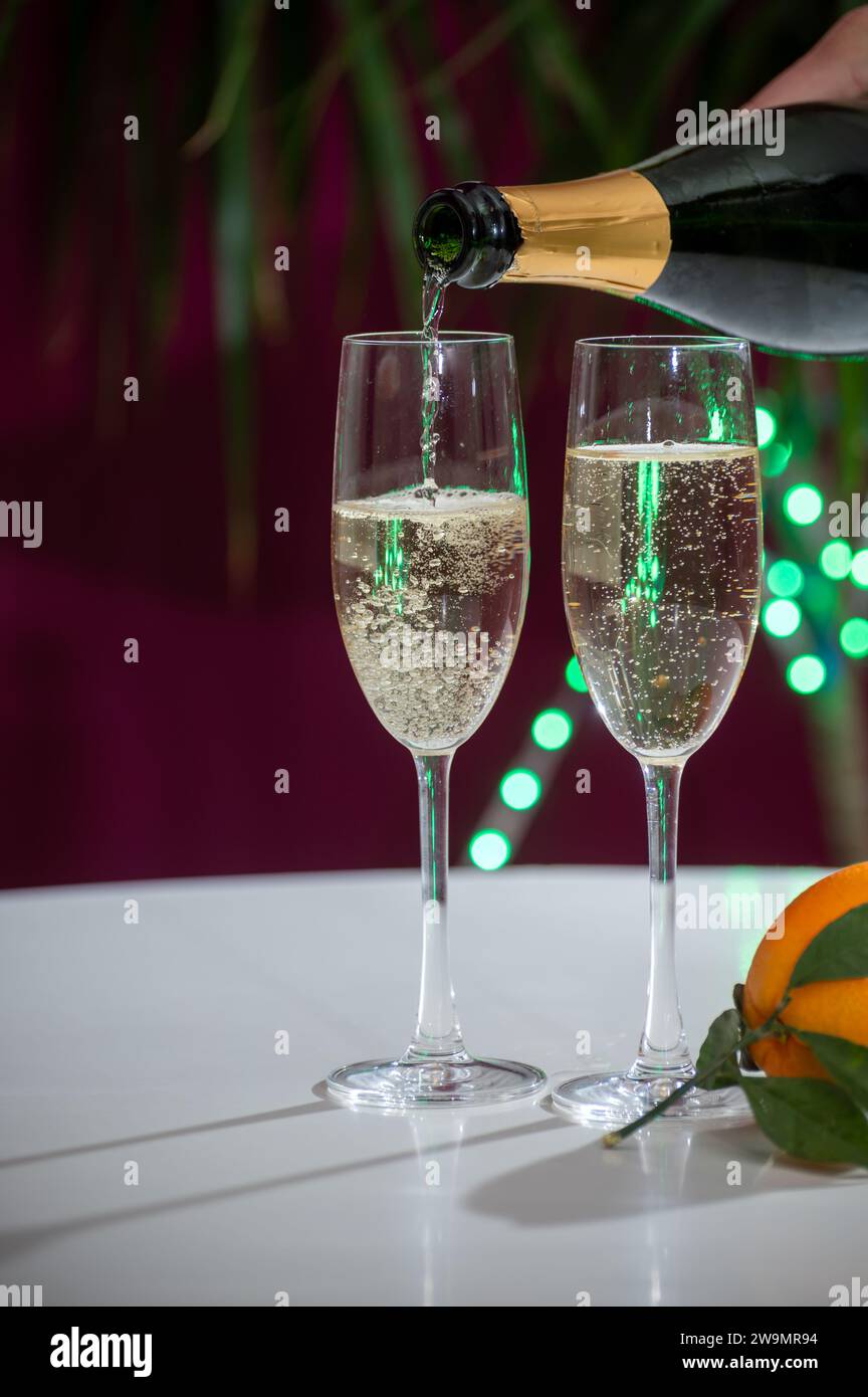 Pouring of brut champagne, cava or prosecco dry wine in glasses with ...