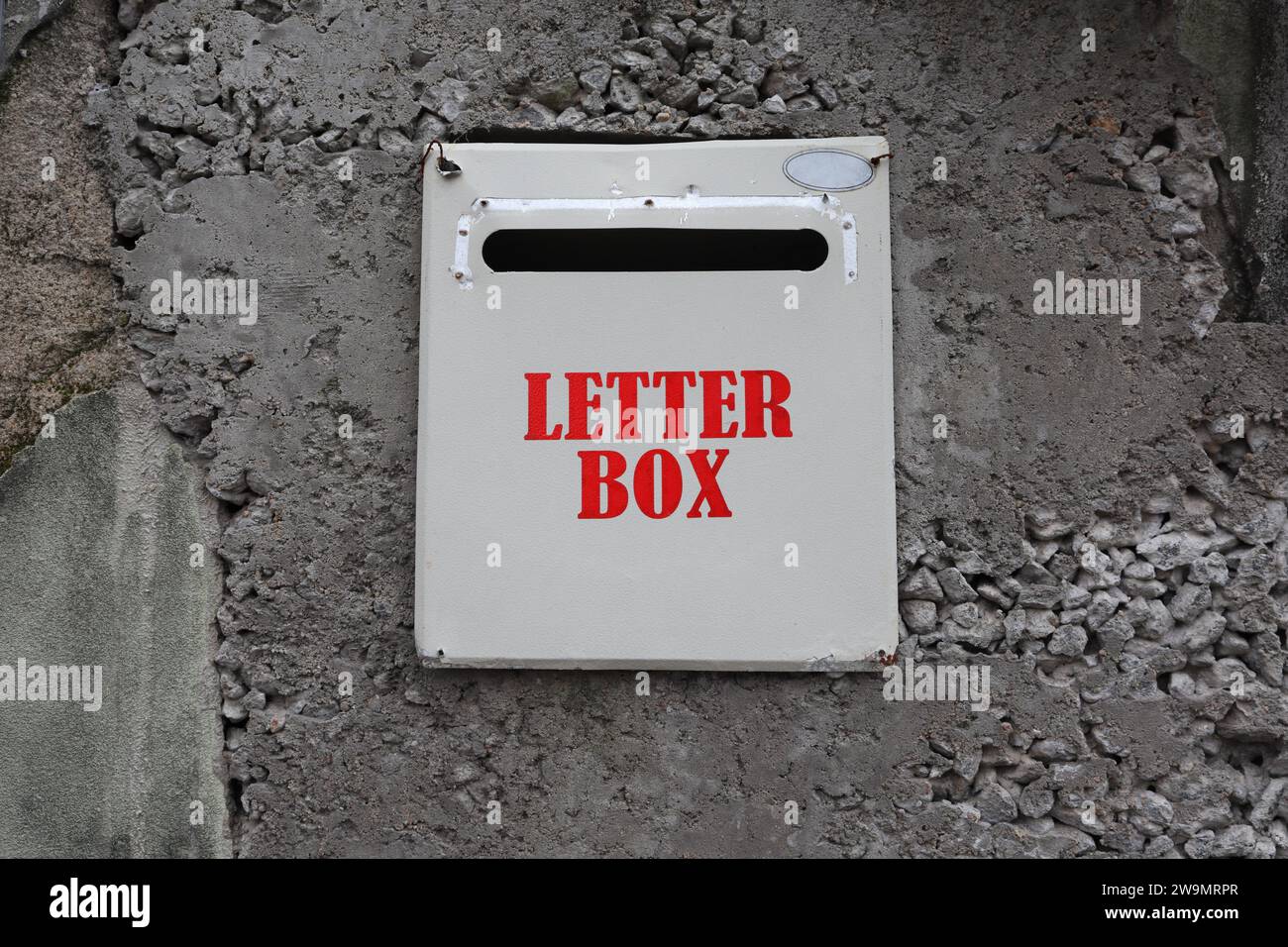 Close up front view of a metal Letter box mounted on a concrete wall ...