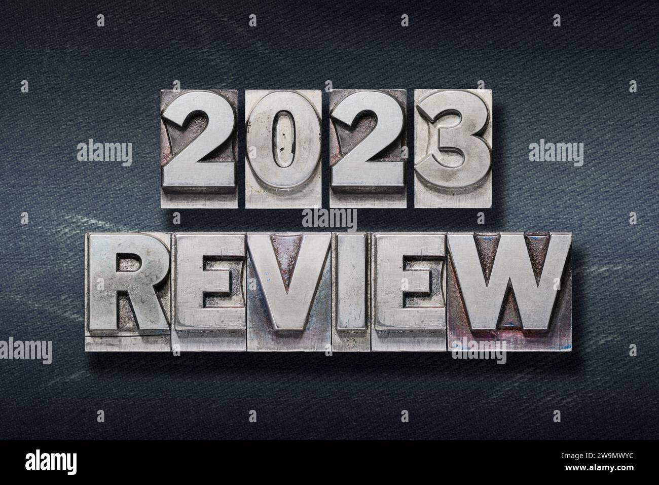 review 2023 phrase made from metallic letterpress on dark background ...