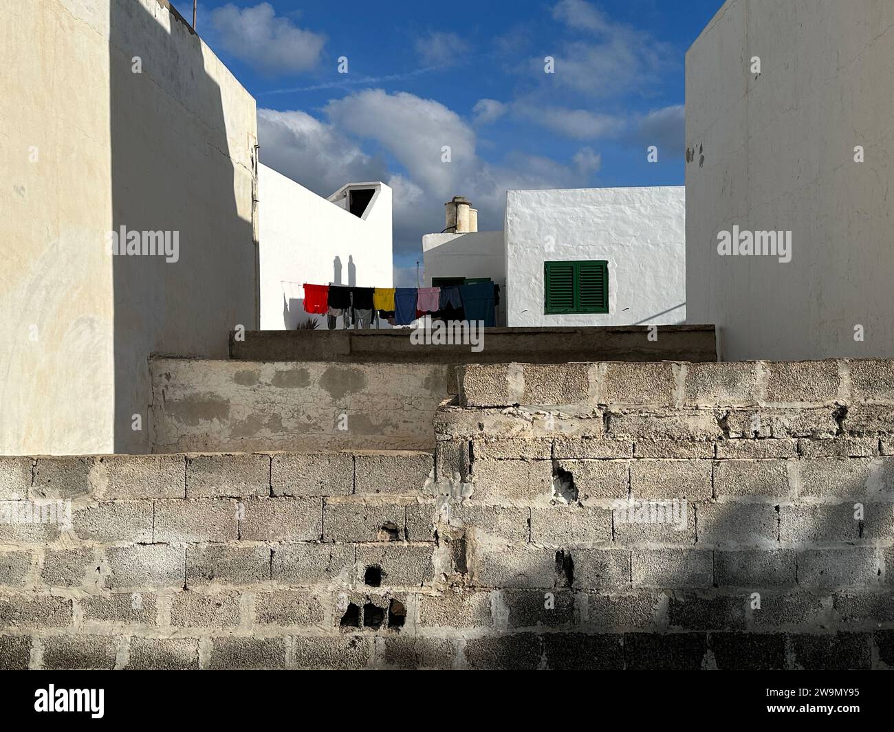 Laundry drying on a clothes line between traditional whitewashed houses ...