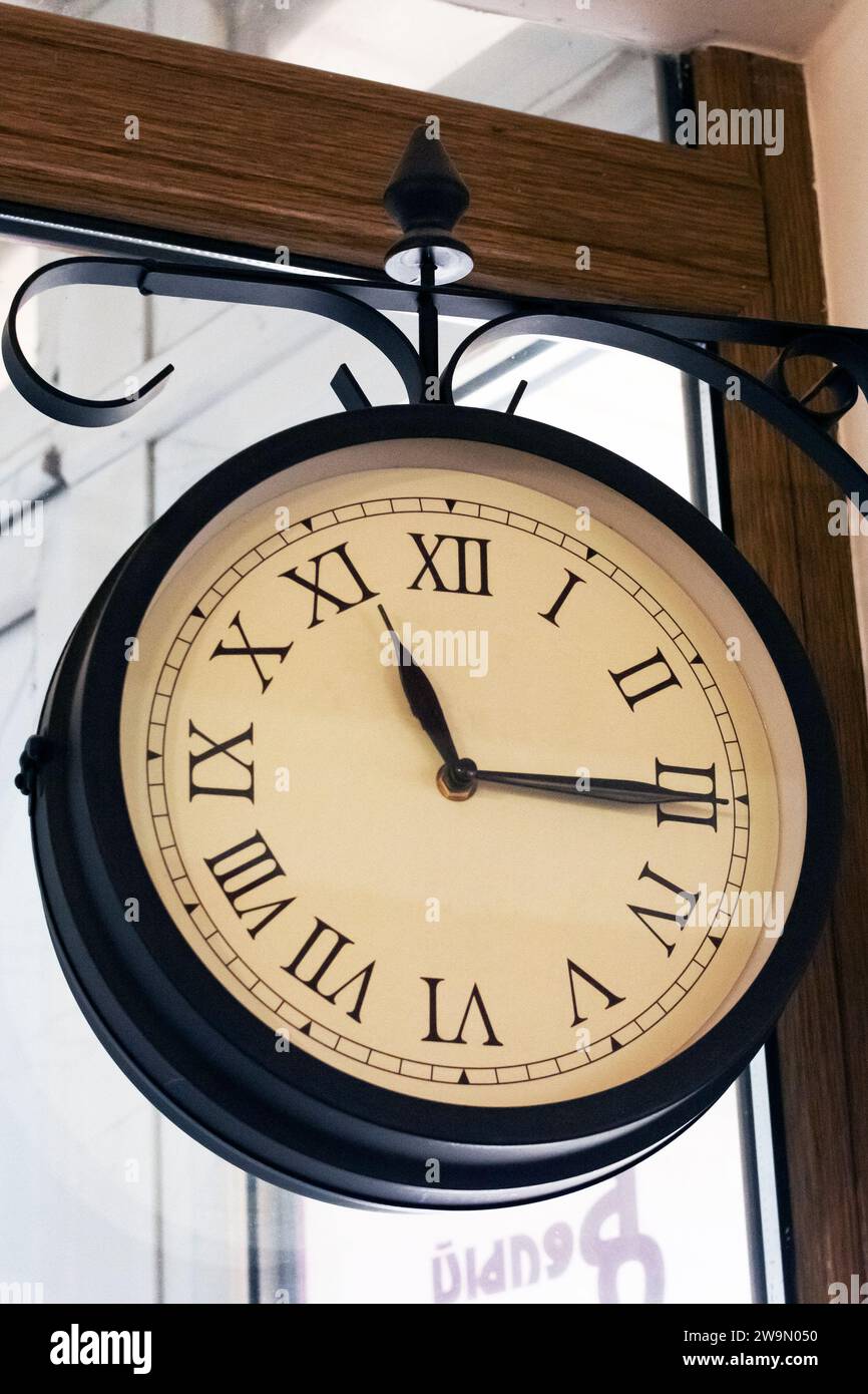 Retro clock with arrows on the wall close up Stock Photo - Alamy