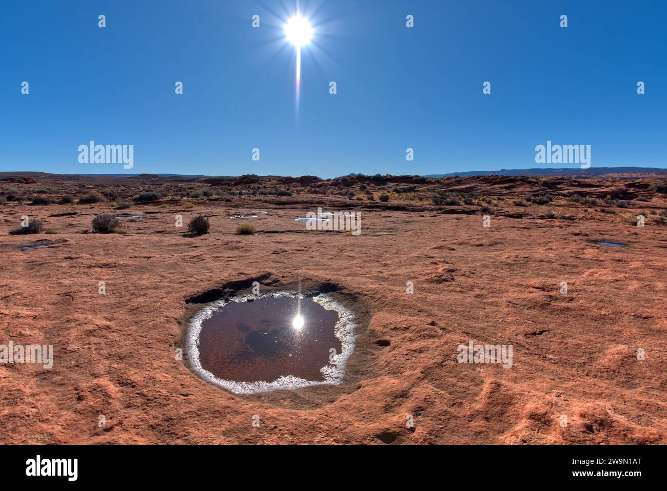 Sunburst over Reflecting Pools of water in the badlands of Horseshoe ...