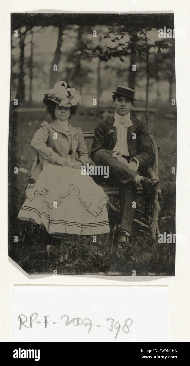 Portrait of a man and woman, sitting on a bench in a forest or park ...