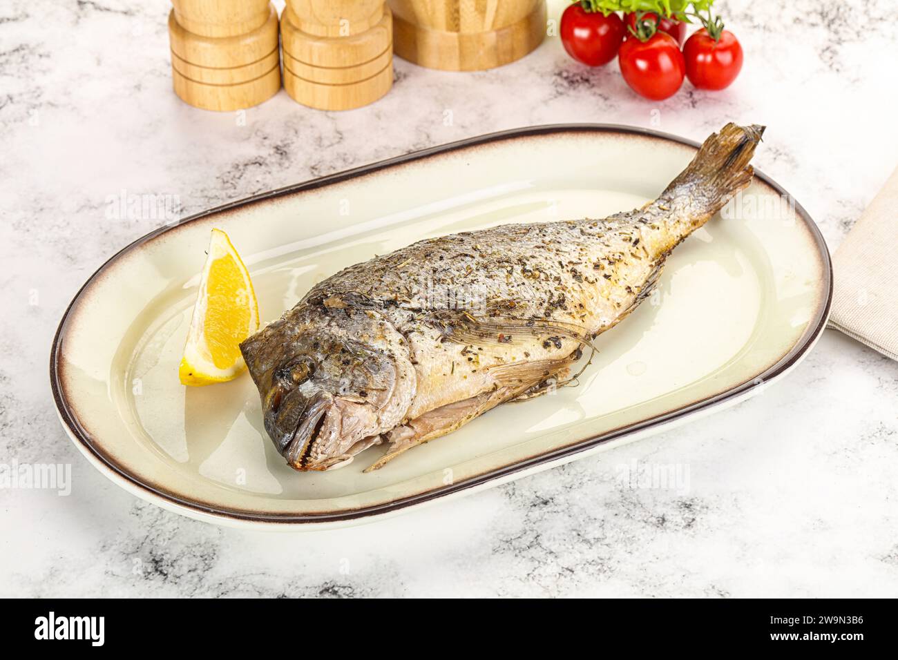Baked Dorado fish served lemon slice Stock Photo - Alamy