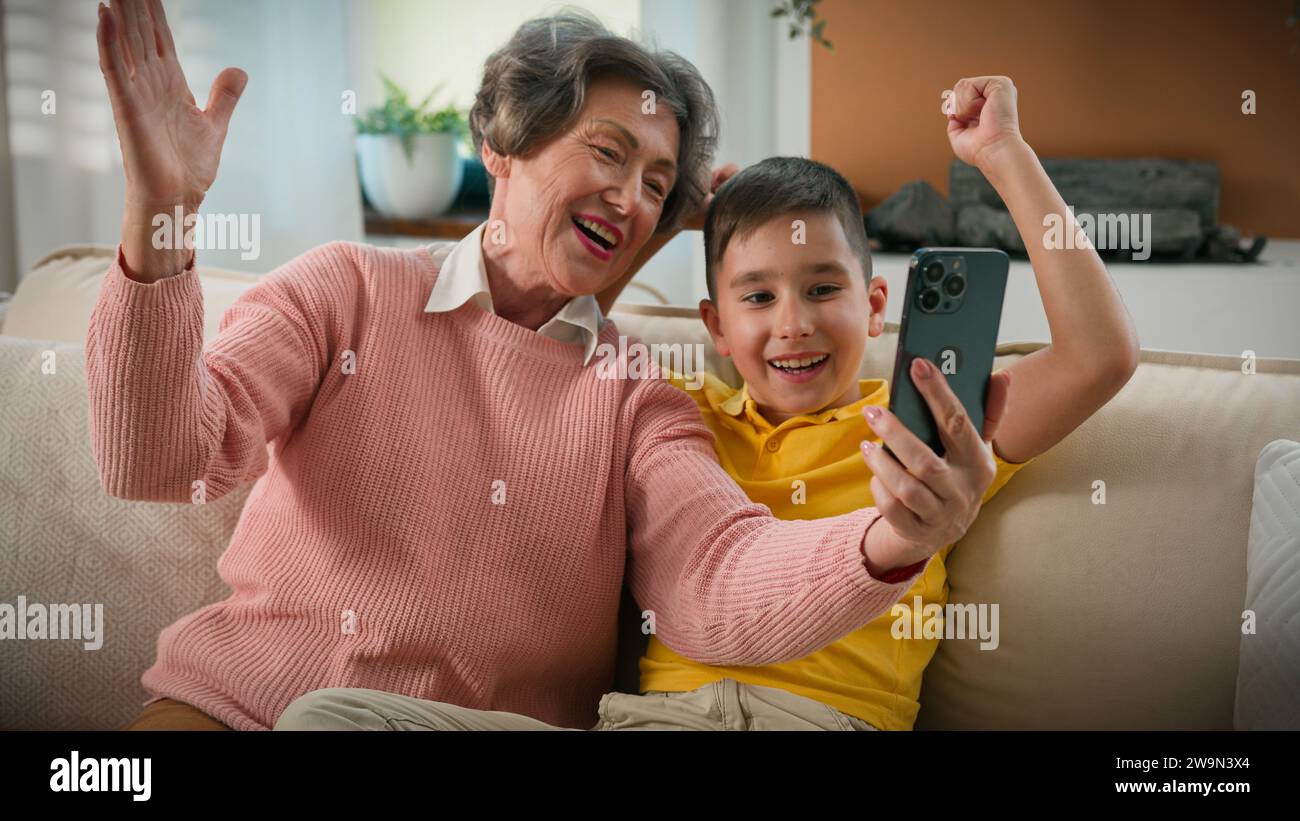 Caucasian grandmother and grandson together at home couch photographed ...