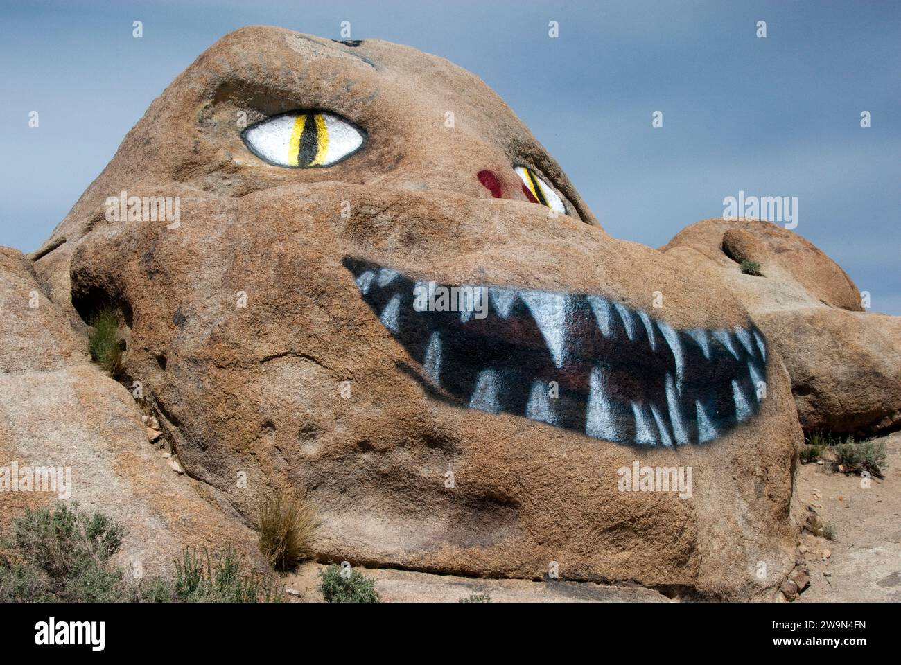 A huge granite boulder is graffitied to look like a monster in the ...