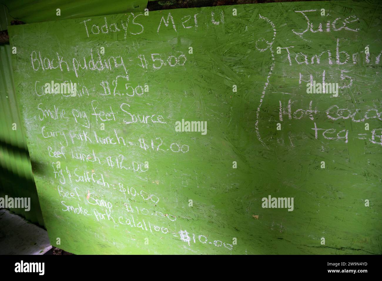 A chalkboard displays the menu of a roadside restaurant and bar on the ...