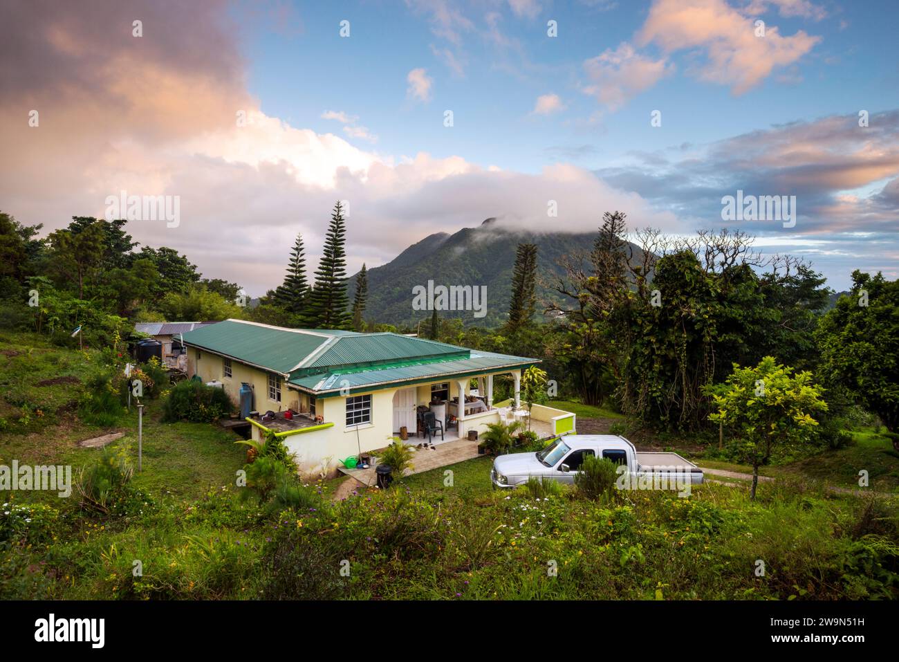 Sunset over a traditional house in the countryside of Dominica. The ...