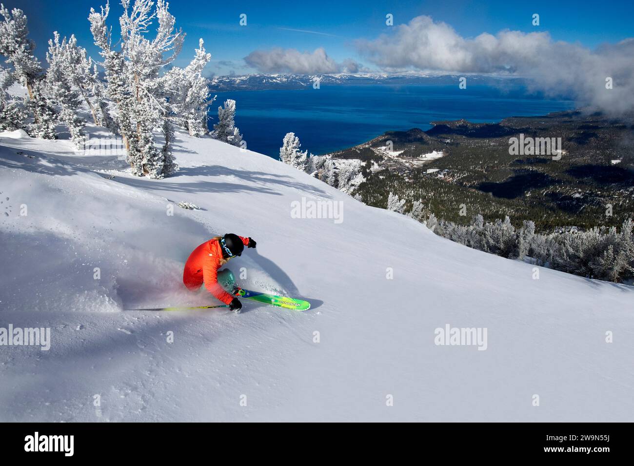 A female skier (Hazel Birnbaum) skis in deep powder on a beautiful day ...