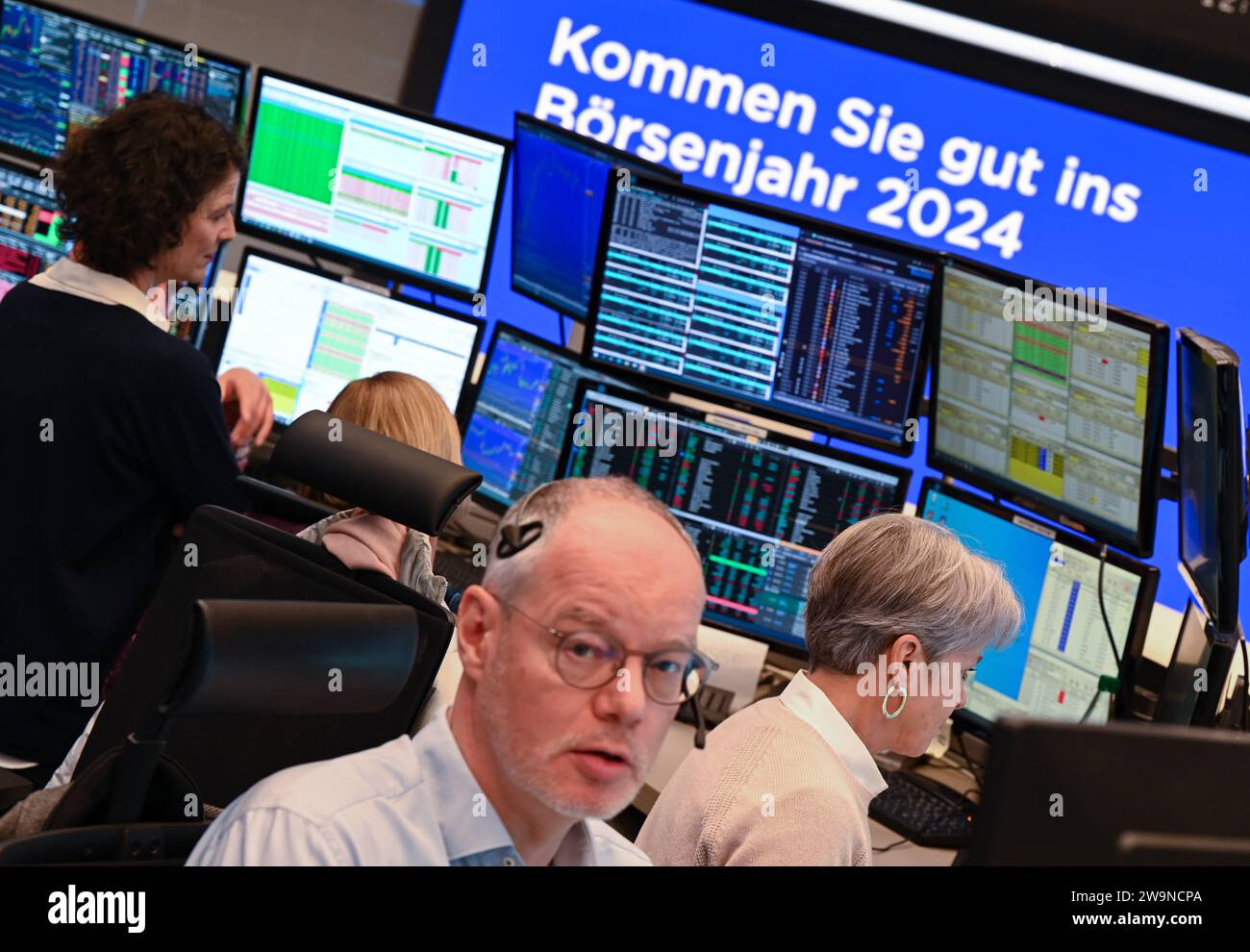 29 December 2023, Hesse, Frankfurt/Main: Traders sit at their monitors ...
