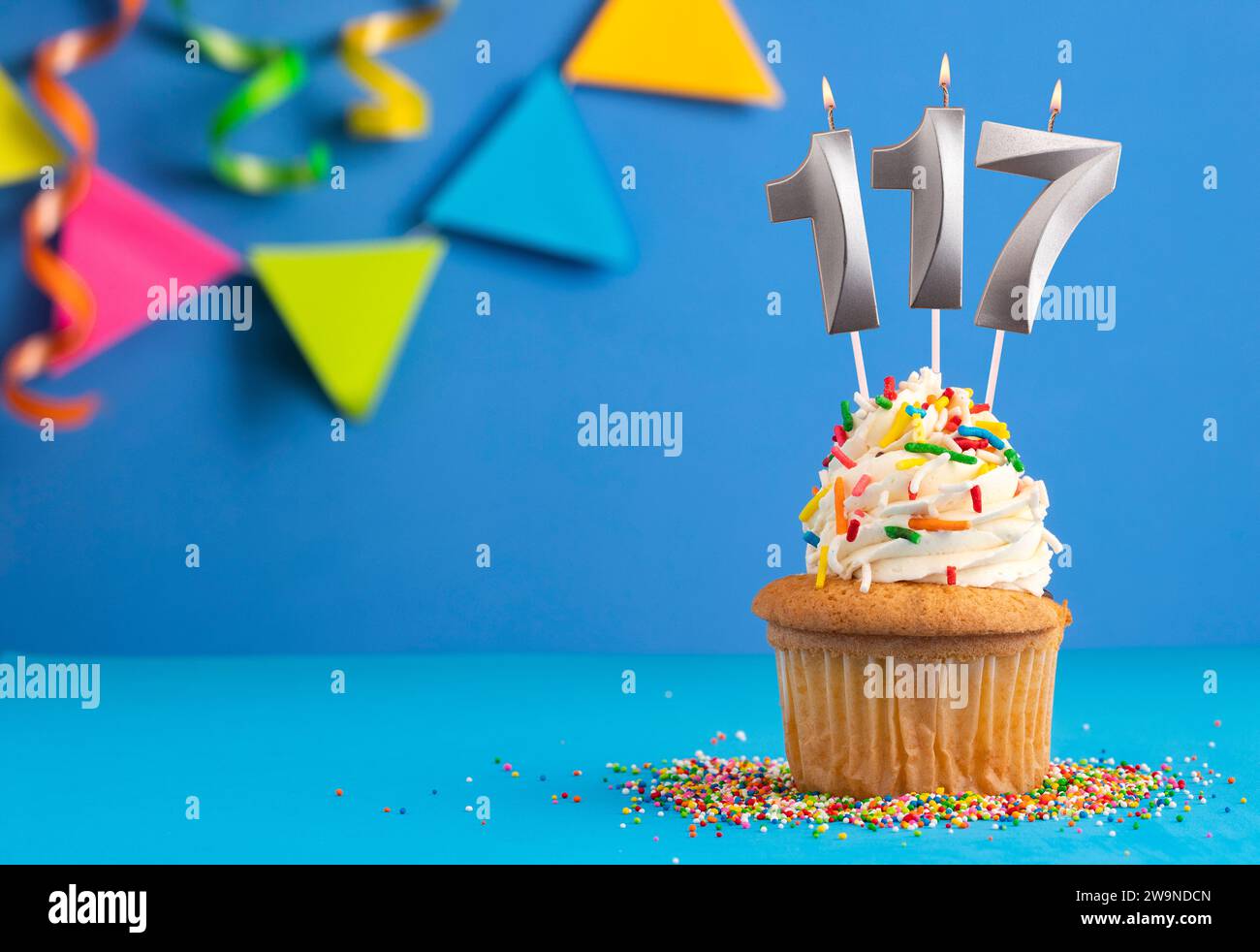 Candle number 117 - Cake birthday in blue background Stock Photo - Alamy