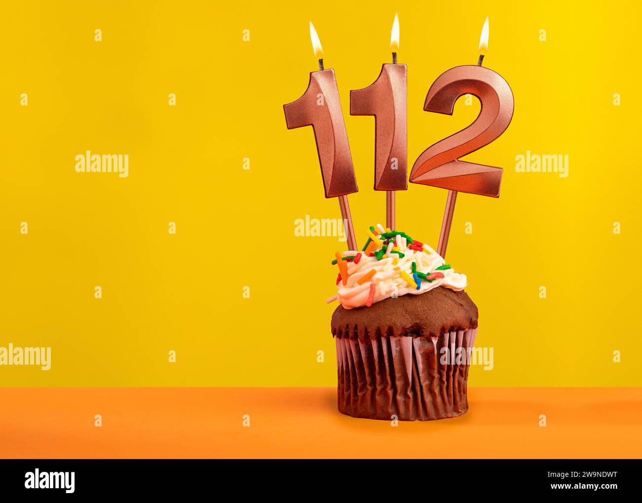 Number 112 birthday candle - Celebration on yellow background Stock ...