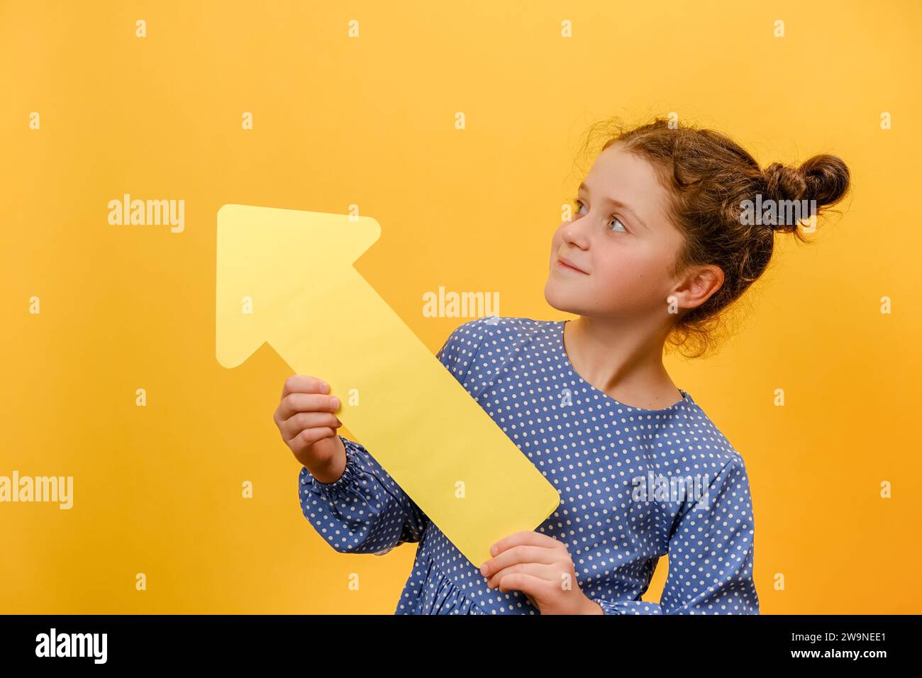 Portrait of smiling cute little girl child holding arrow, looking at ...