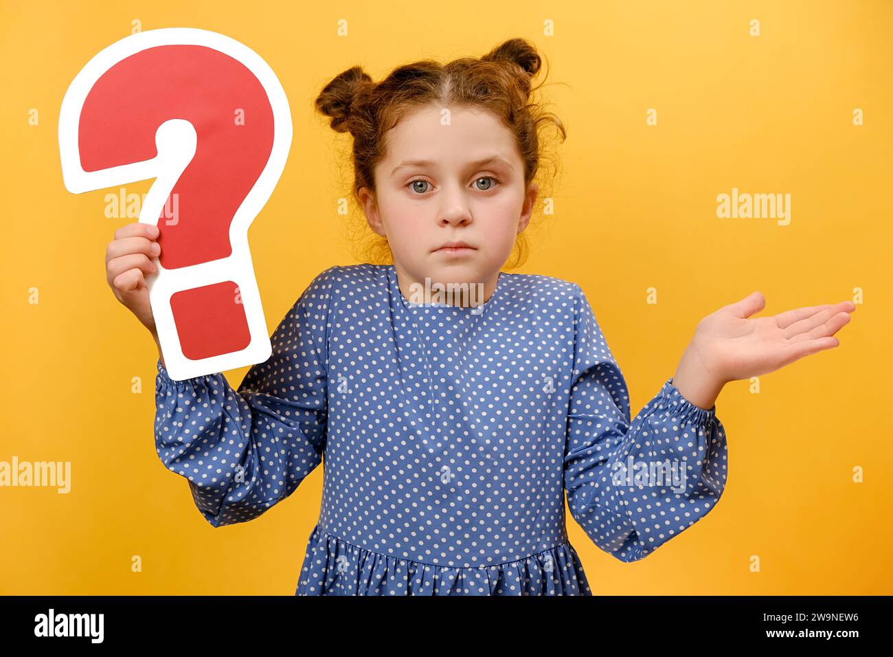 Portrait of pensive little girl kid 7-8 old years holding red question ...