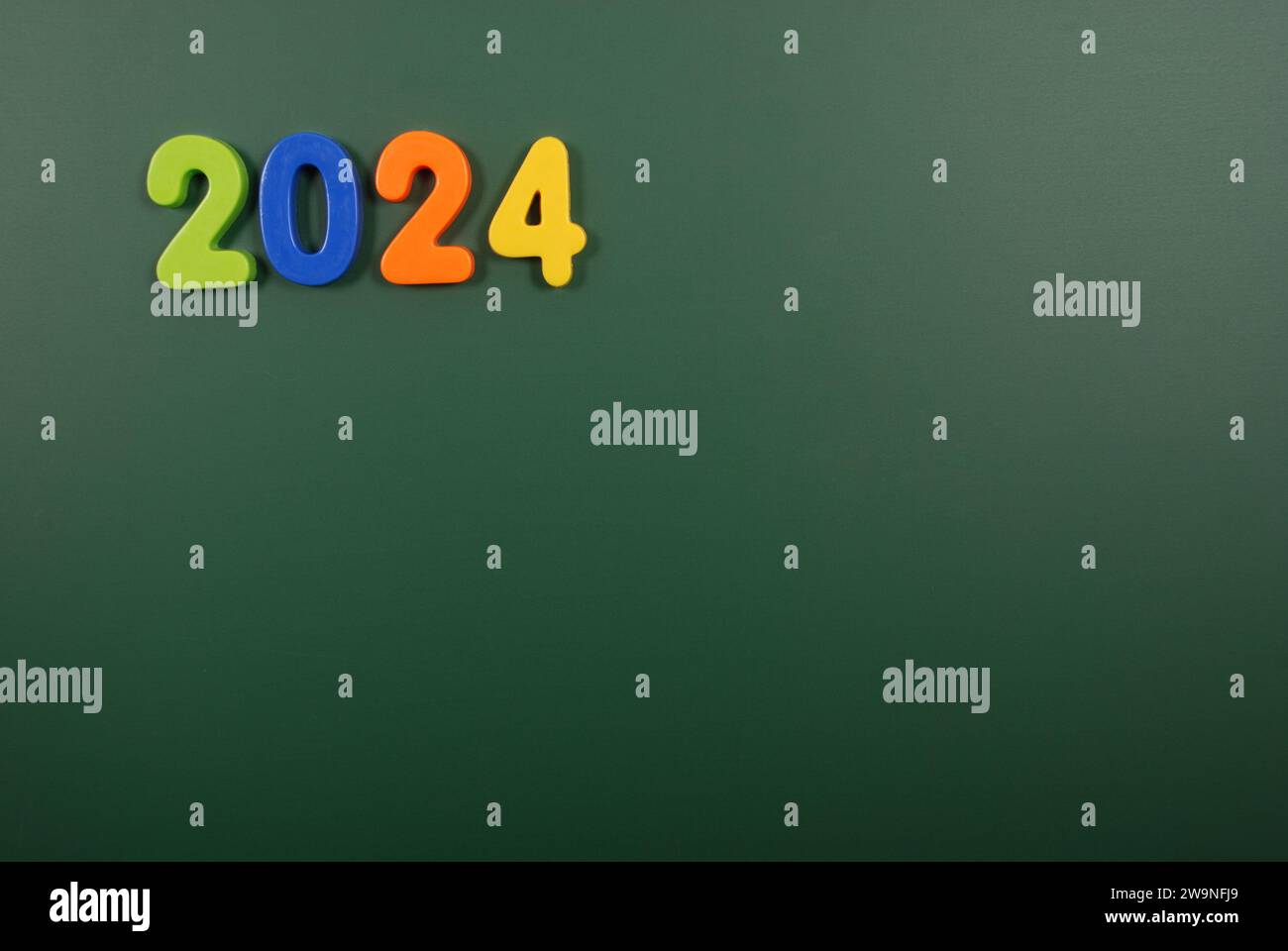 2024 year written in bright plastic magnetic letters stuck on a ...