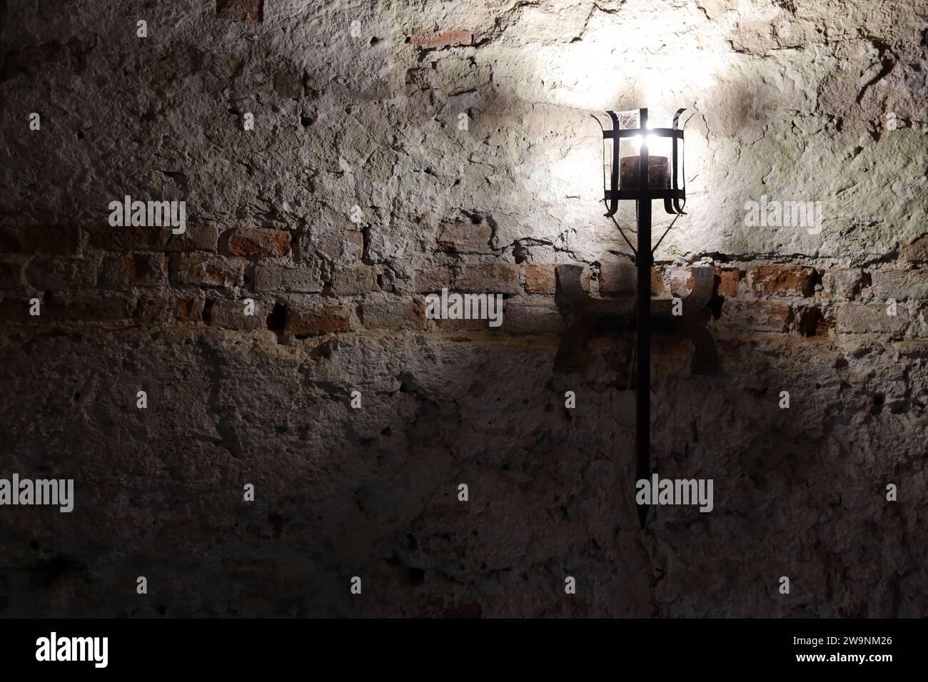 Lighted medieval castle torch hanging on a stone wall, vintage objects ...
