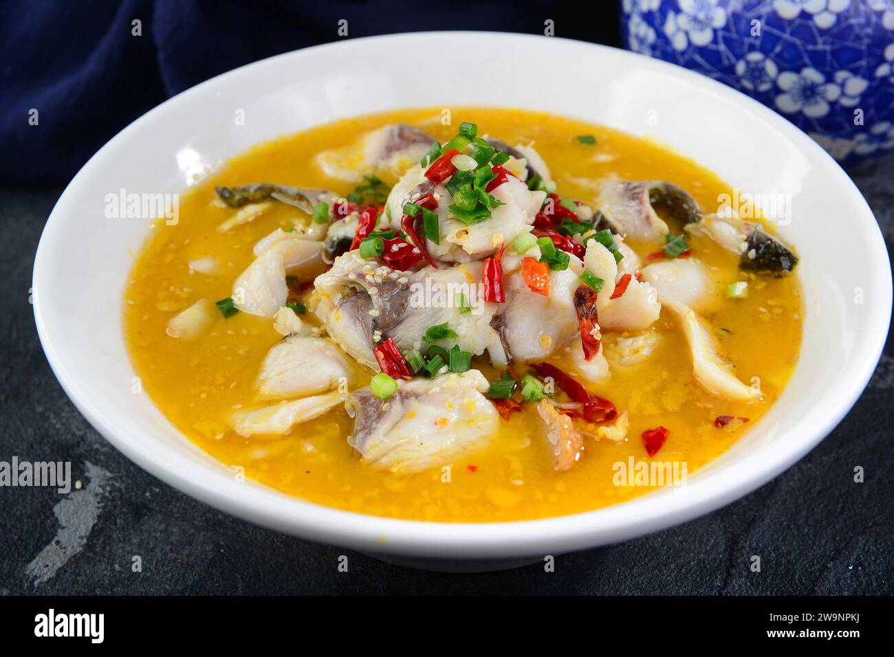 Closeup chopsticks pick a piece of fish meat from Sichuan Fish (Suan ...