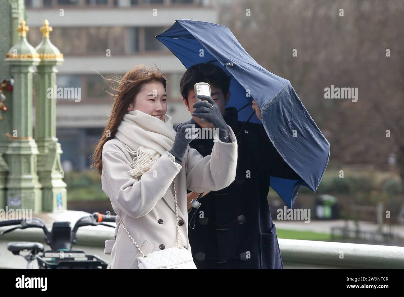 London, UK. 28th Dec, 2023. A couple takes photographs during windy and ...