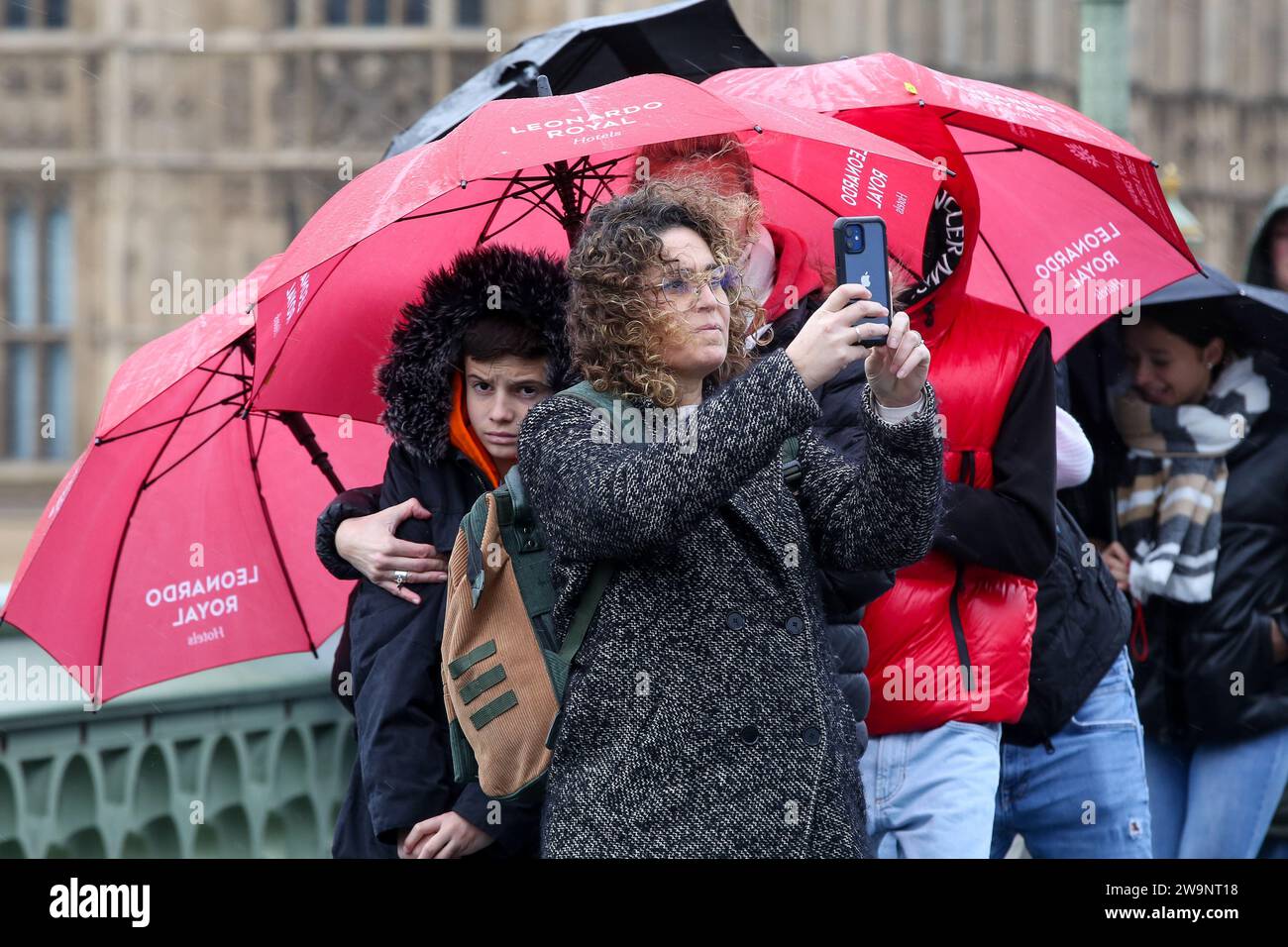 London, UK. 28th Dec, 2023. A woman takes photographs of London Eye ...