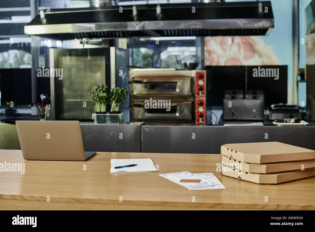 laptop near pizza boxes and menu cards on wooden counter in modern cafe ...