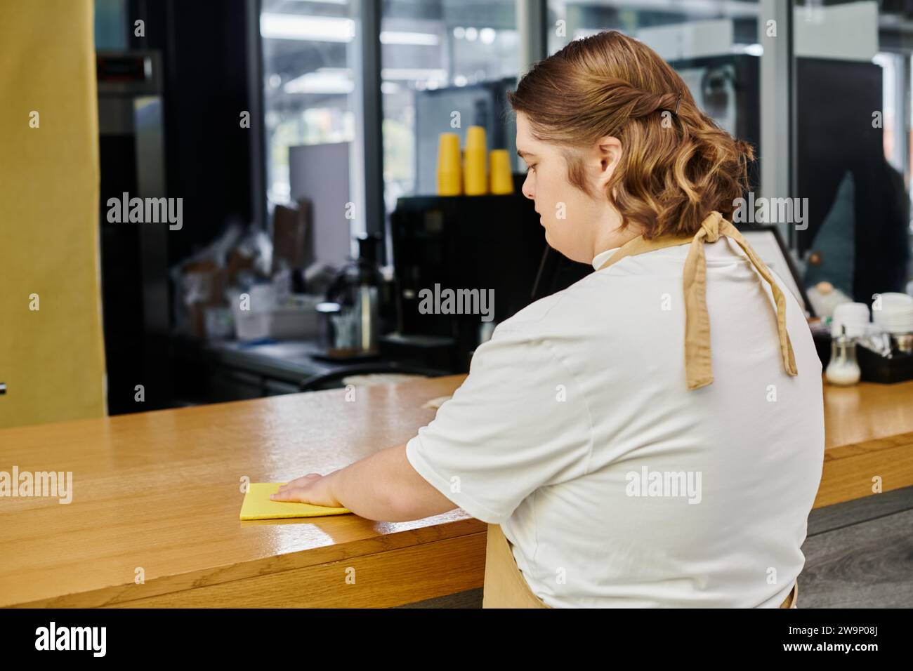 young female employee with down syndrome working in modern cafe and ...