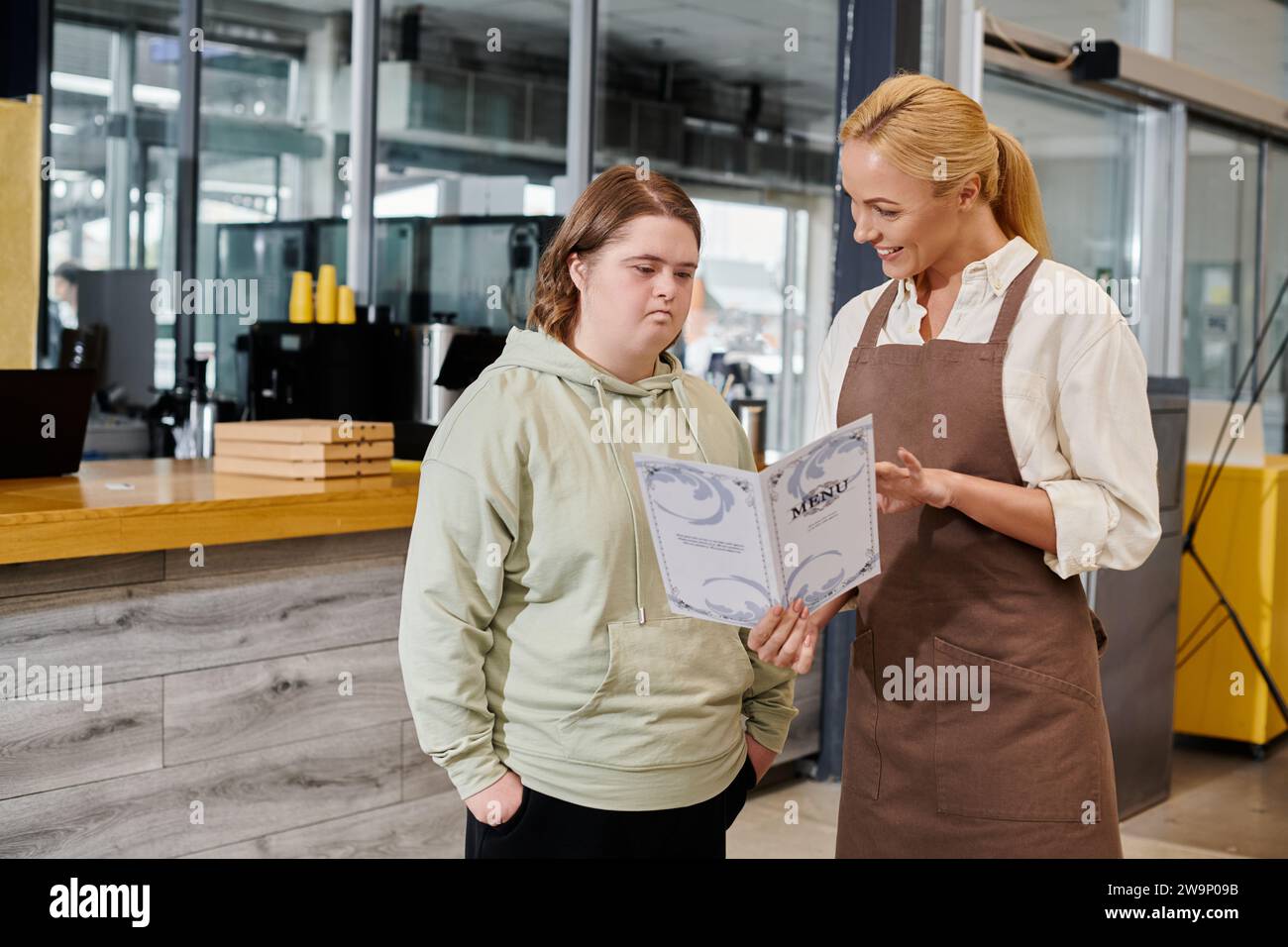smiling female administrator showing menu card to thoughtful woman with ...