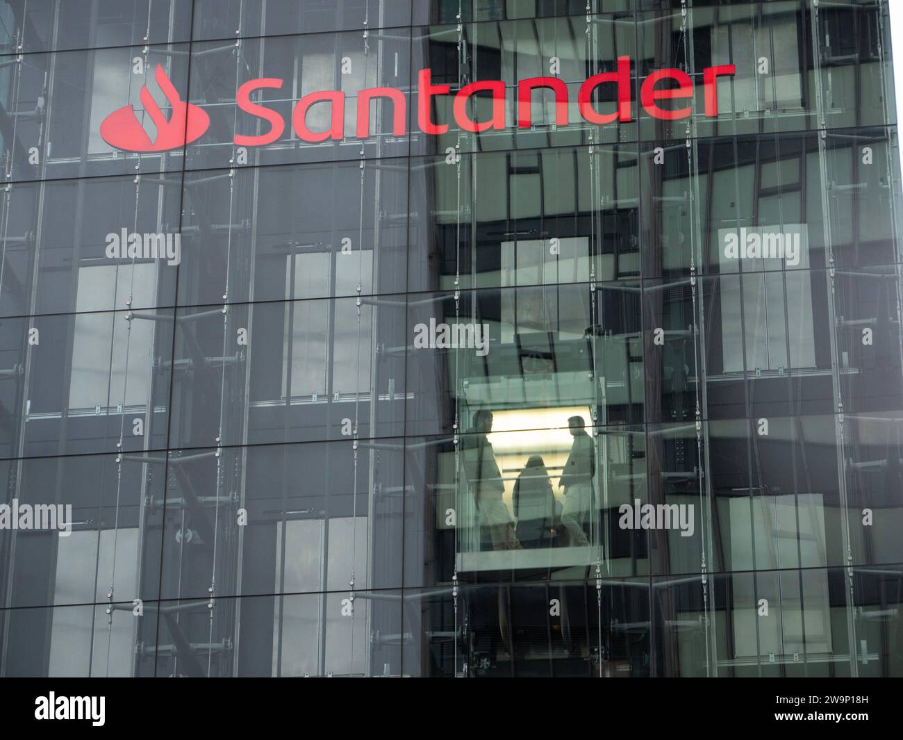 Passengers and office staff travel in a glass-walled lift at the ...