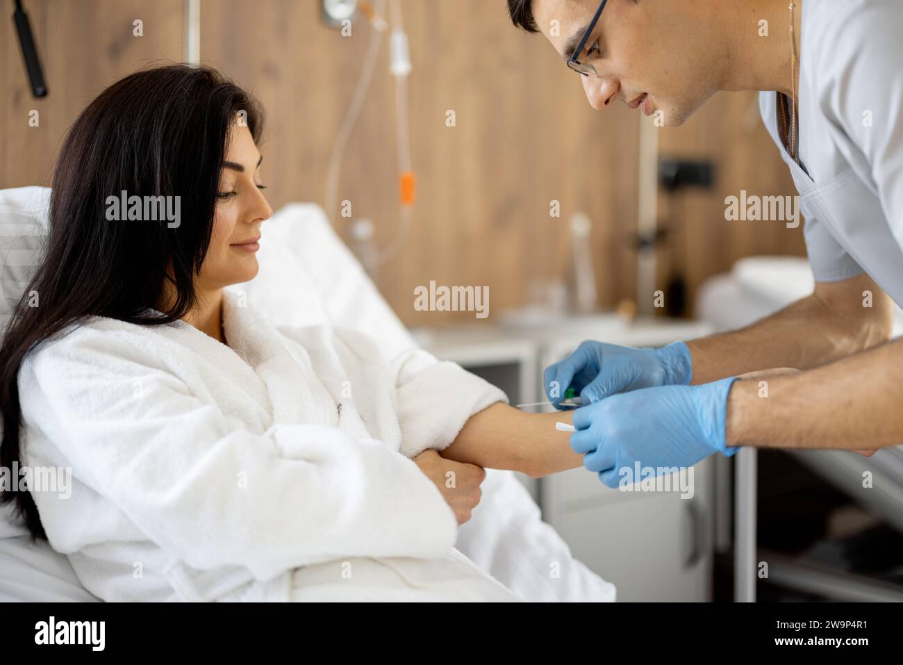 Nurse inserts catheter to a female patient in medical ward Stock Photo ...