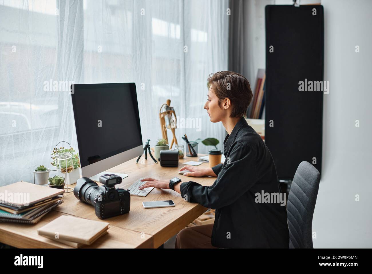 charming professional female photographer in casual wear retouching ...