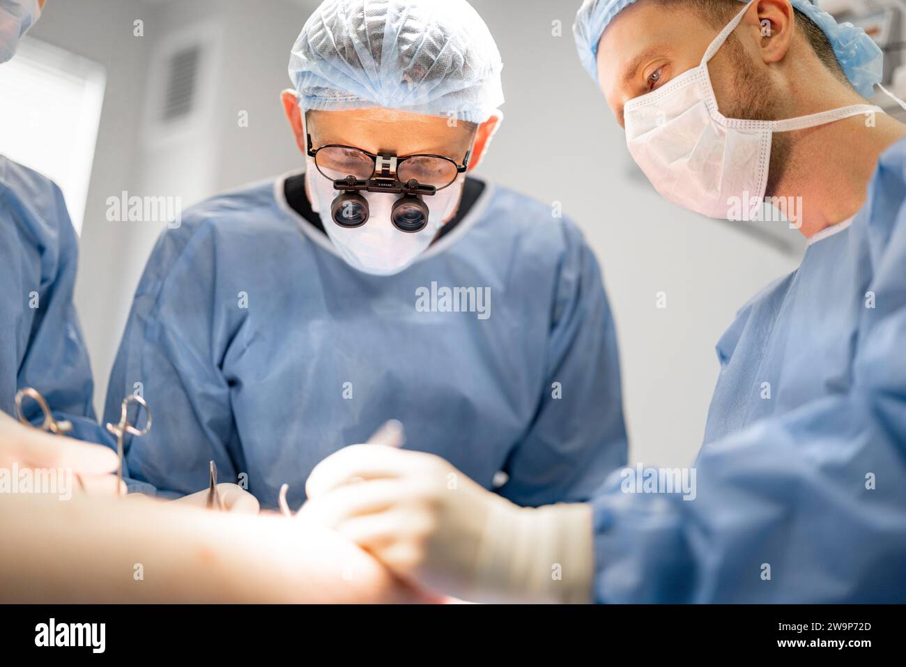 Surgeon with microscope glasses during an operation Stock Photo - Alamy