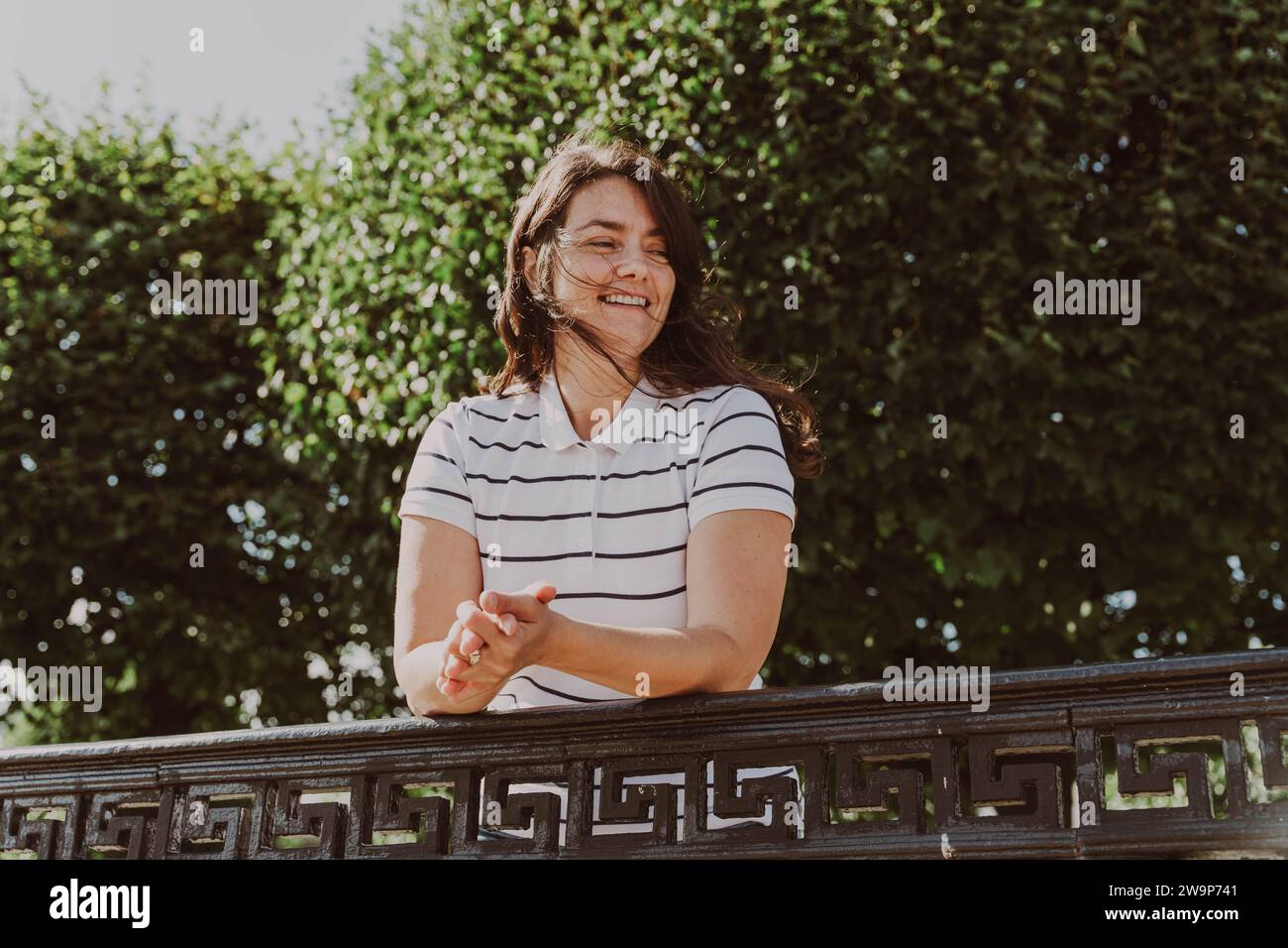 Radiant and elegant, a middle-aged woman with long hair exudes charm ...