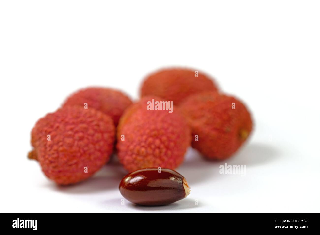 Lychee seeds and lychees against a white background Stock Photo - Alamy