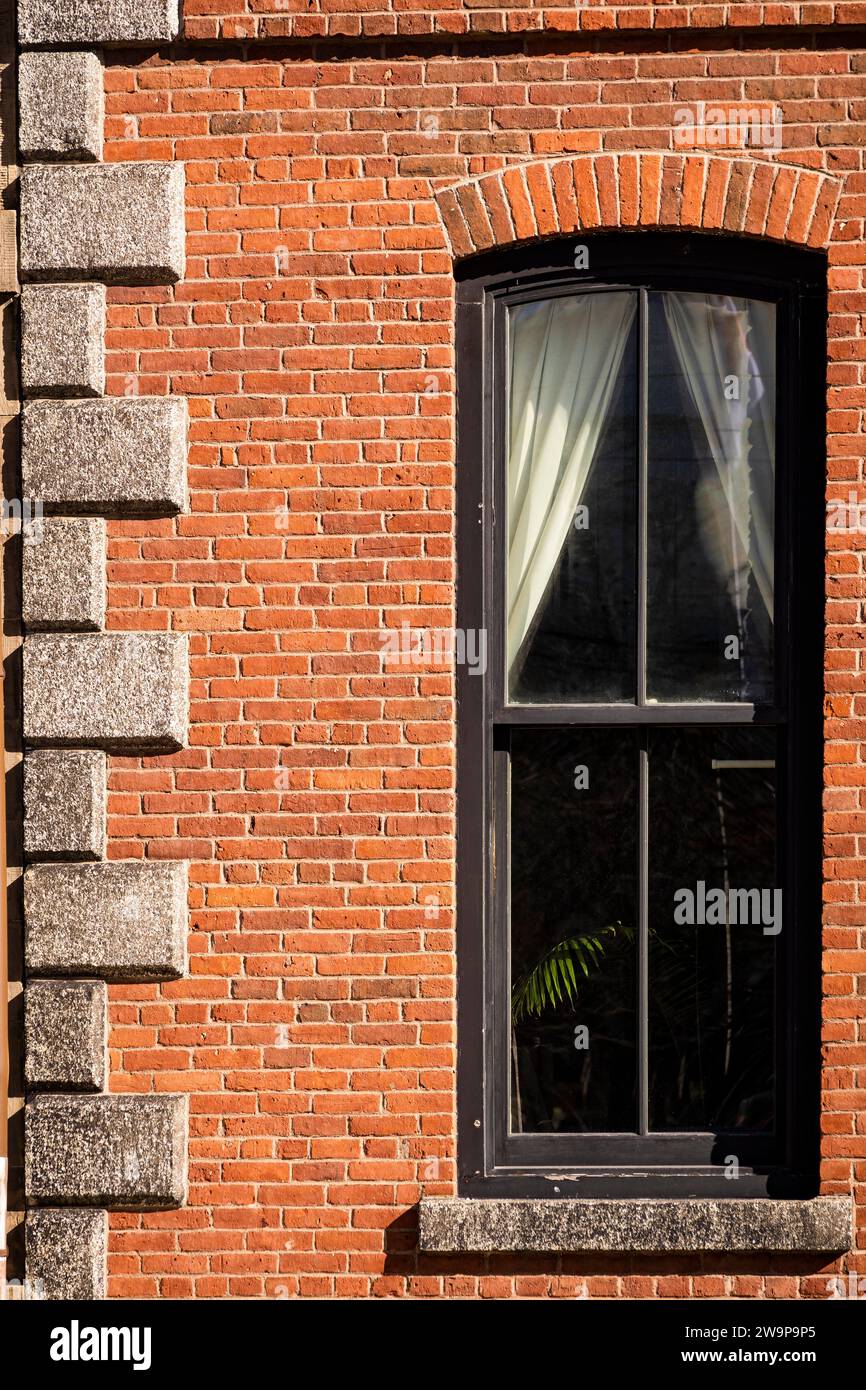 Window in a brick building near the decorative stone flourish at the ...