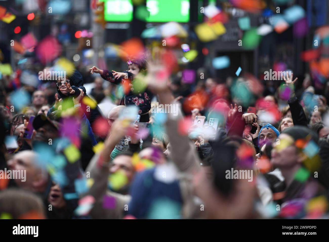 New York, USA. 29th Dec, 2023. People reach for floating confetti ...