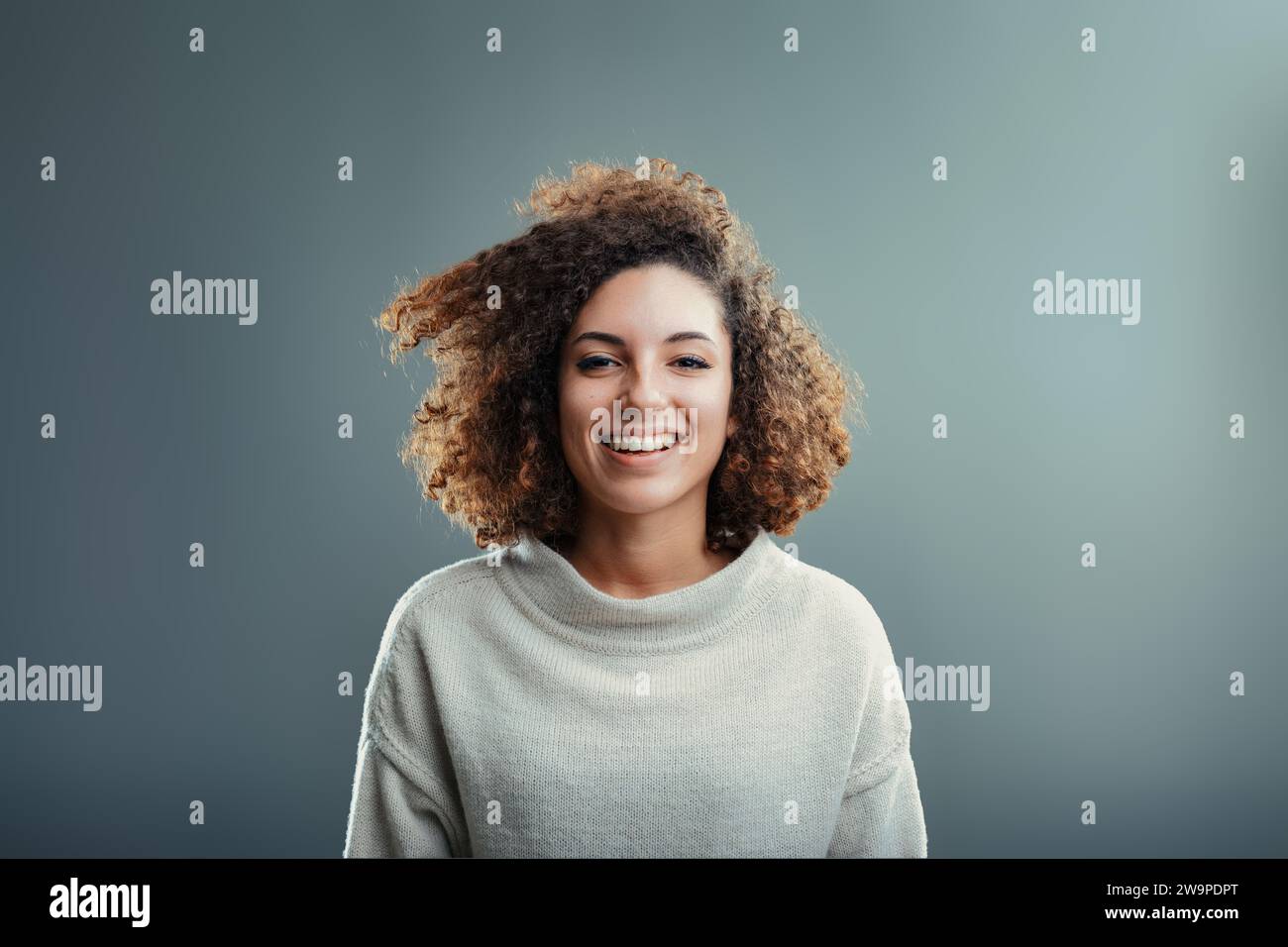 Joyful expression dominates the visage of a young woman with bouncy ...