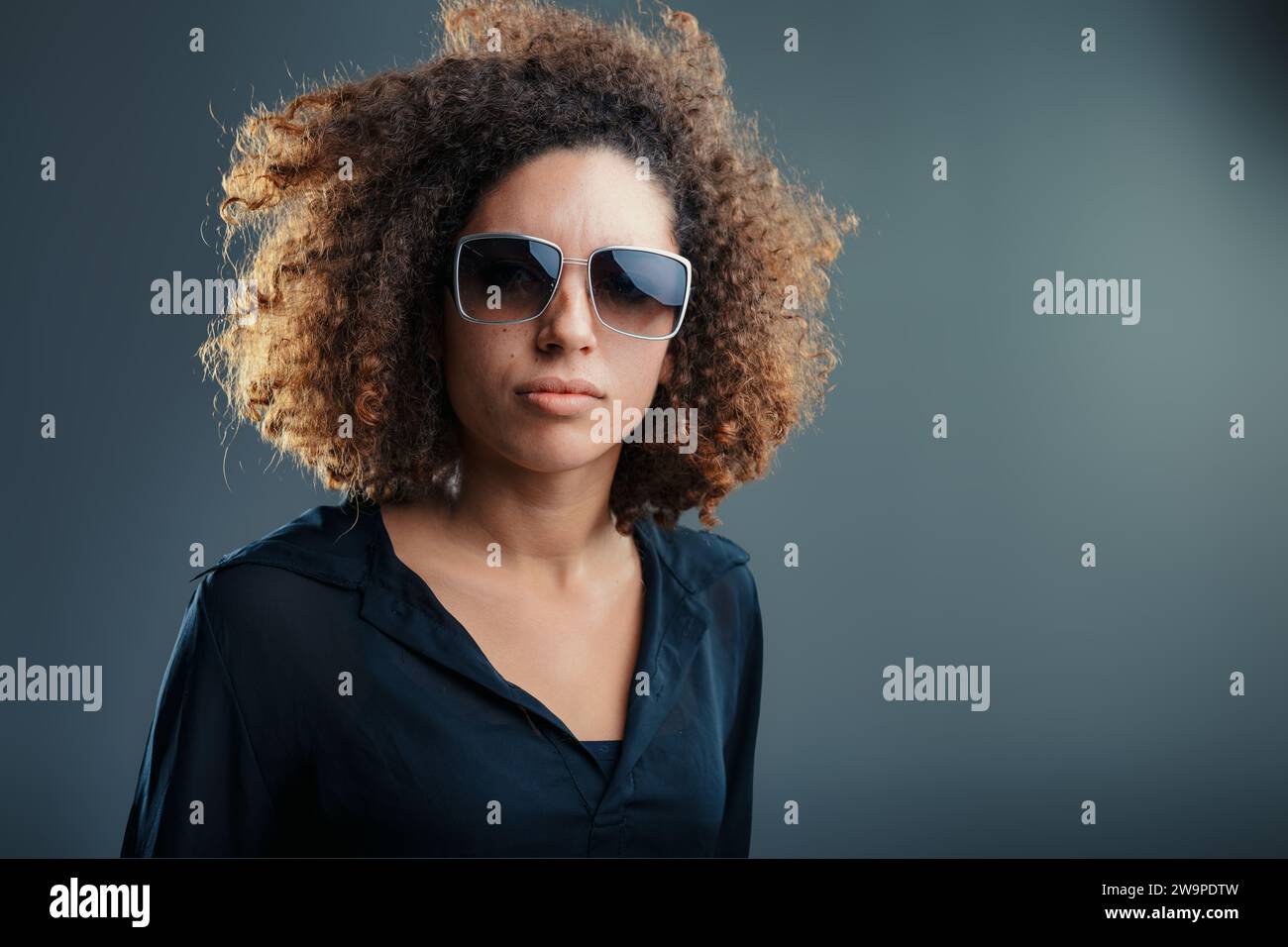Her fierce look behind sunglasses and untamed curls reflects a strong ...