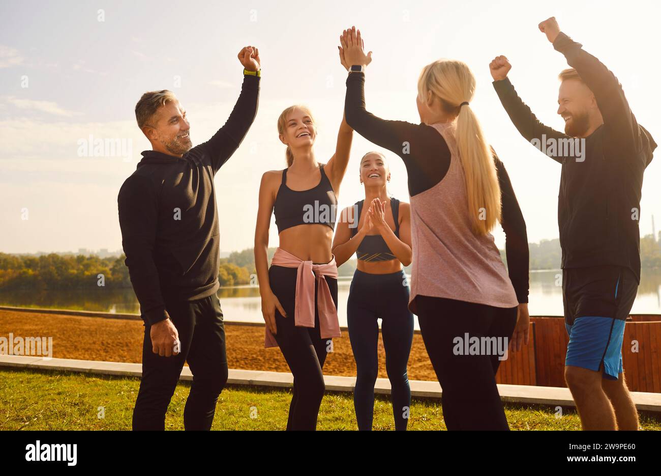 Sporting Friends Exchange High Five in the Park Stock Photo - Alamy