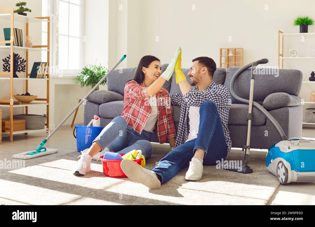 Positive Couple Giving High Five Amidst Household Cleaning Stock Photo ...