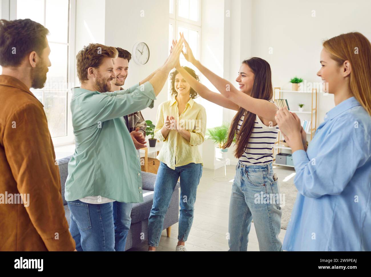 Group of excited happy friends greeting each other giving high five ...