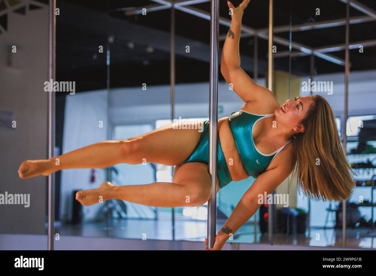 Freely expressing herself in a Mexican pole performance, the woman of Latin American descent ...
