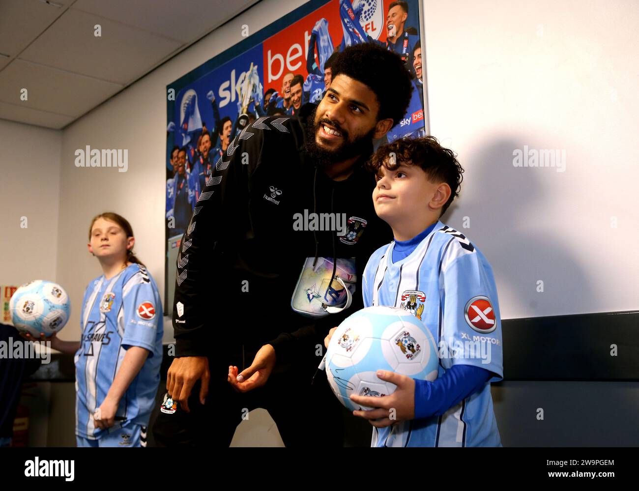 Coventry City's Ellis Simms poses for a photo with a matchday mascot ...