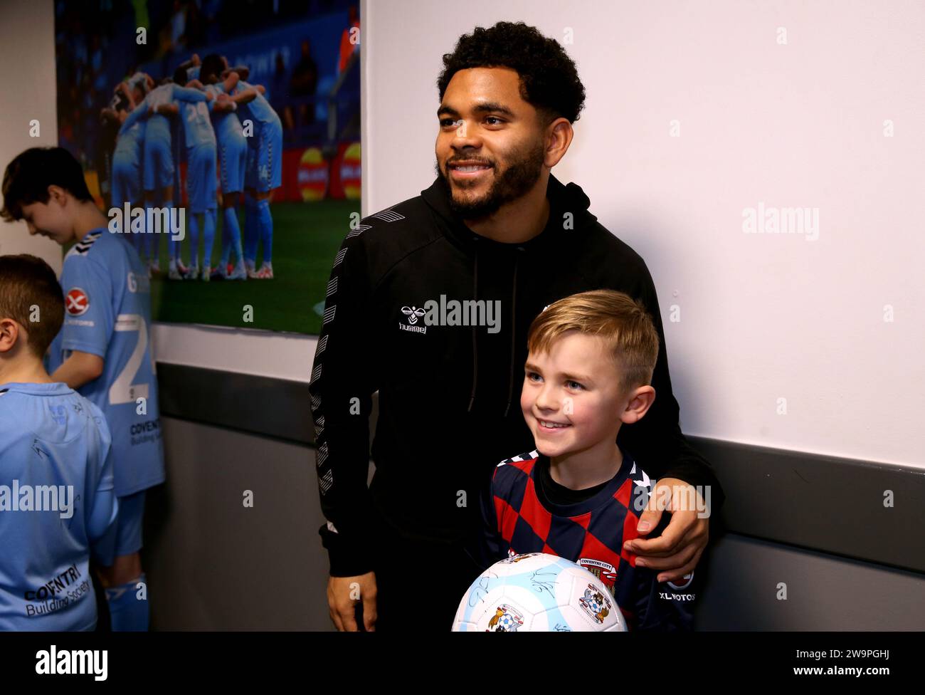Coventry City's Jay Dasilva poses for a photo with a matchday mascot ...